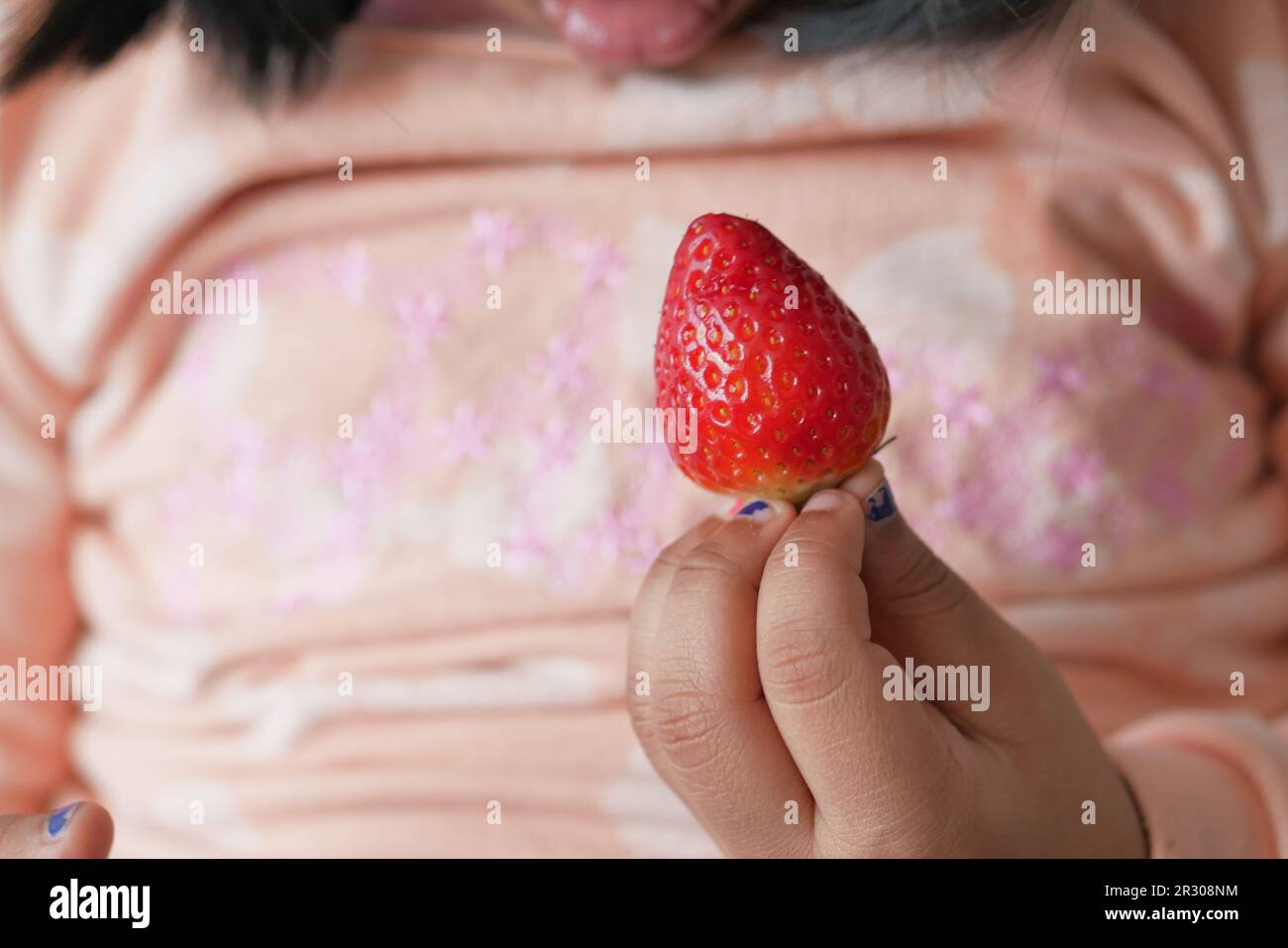 baby hand holding a Strawberry Stock Photo - Alamy