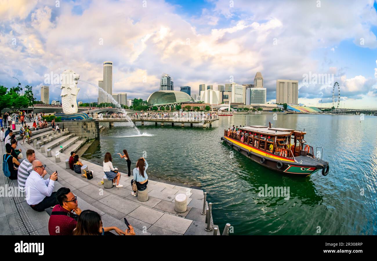 Bum Boat crusing in Singapore River with Merlion and Marina Bay skyline ...