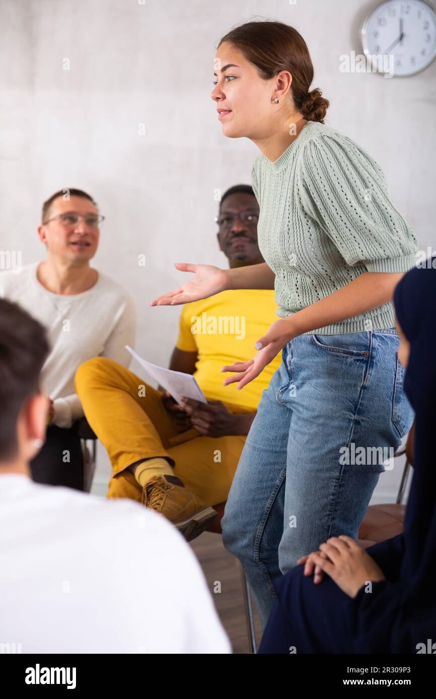 Woman tells an interesting story. Multinational students listening ...