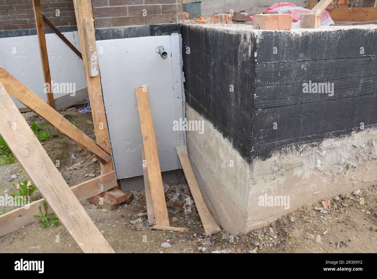 External house basement foundation wall insulation with rigid foam board before waterproofing ...