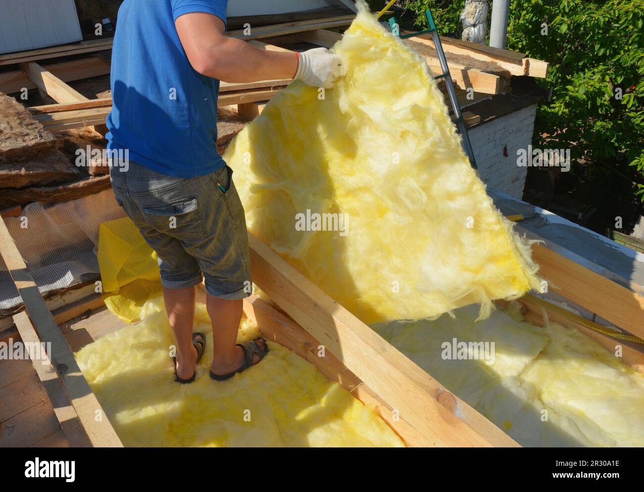 Roofer contractor laying insulation during house rooftop renovation ...
