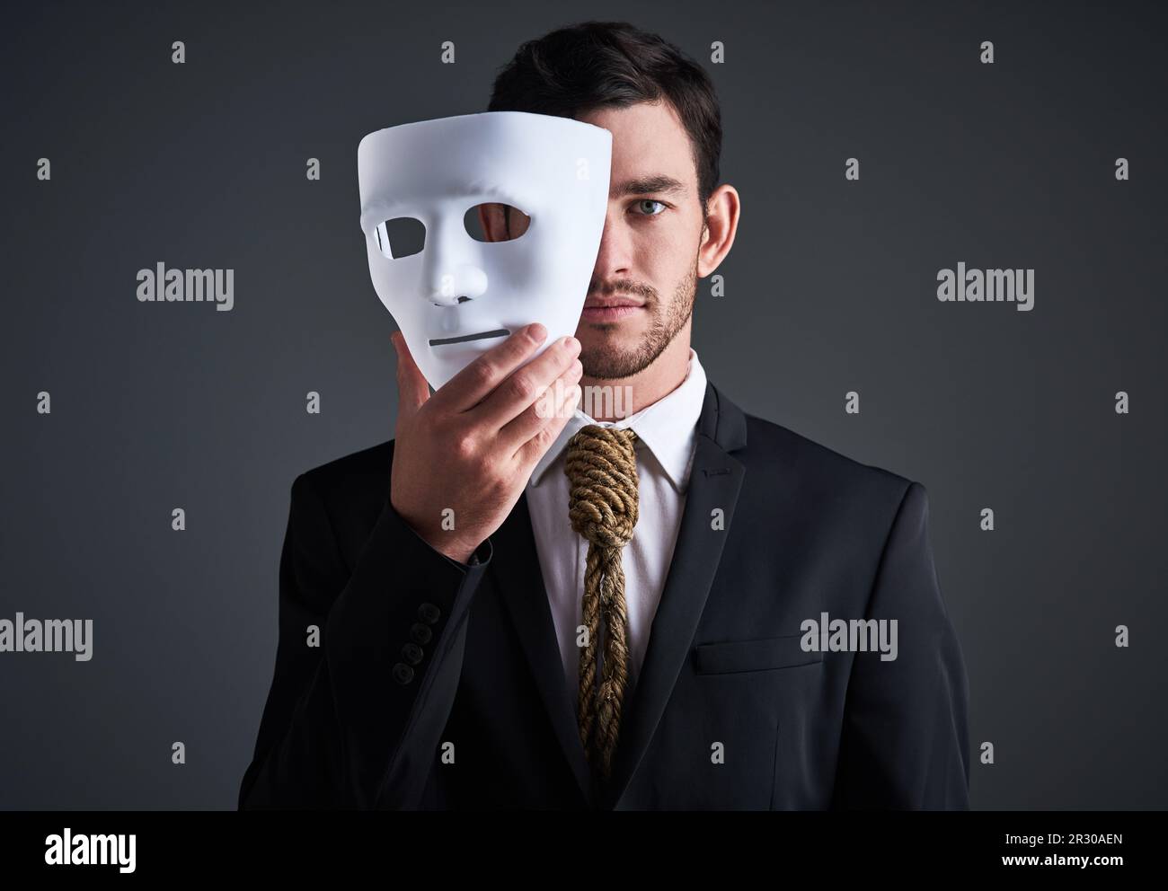Two faces, holding mask and businessman portrait in a studio with ...