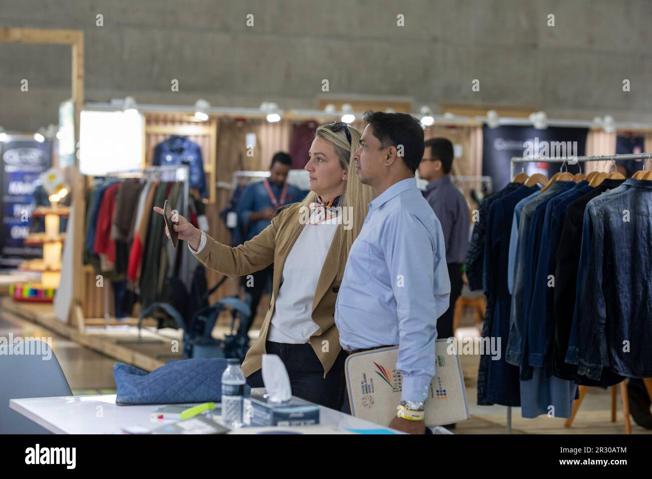 Potential customers browse around a stall at the Bangladesh Denim Expo ...