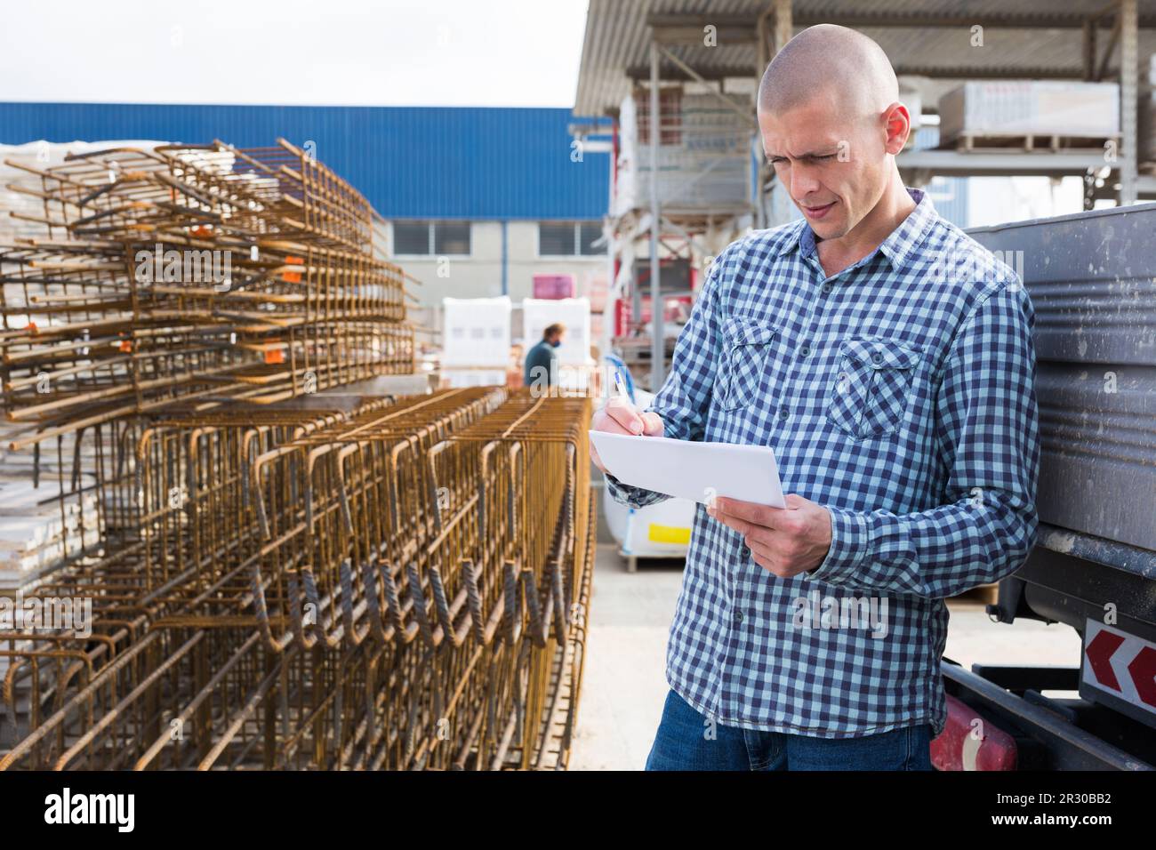 Worker prepares metal rebar for loading onto truck Stock Photo - Alamy