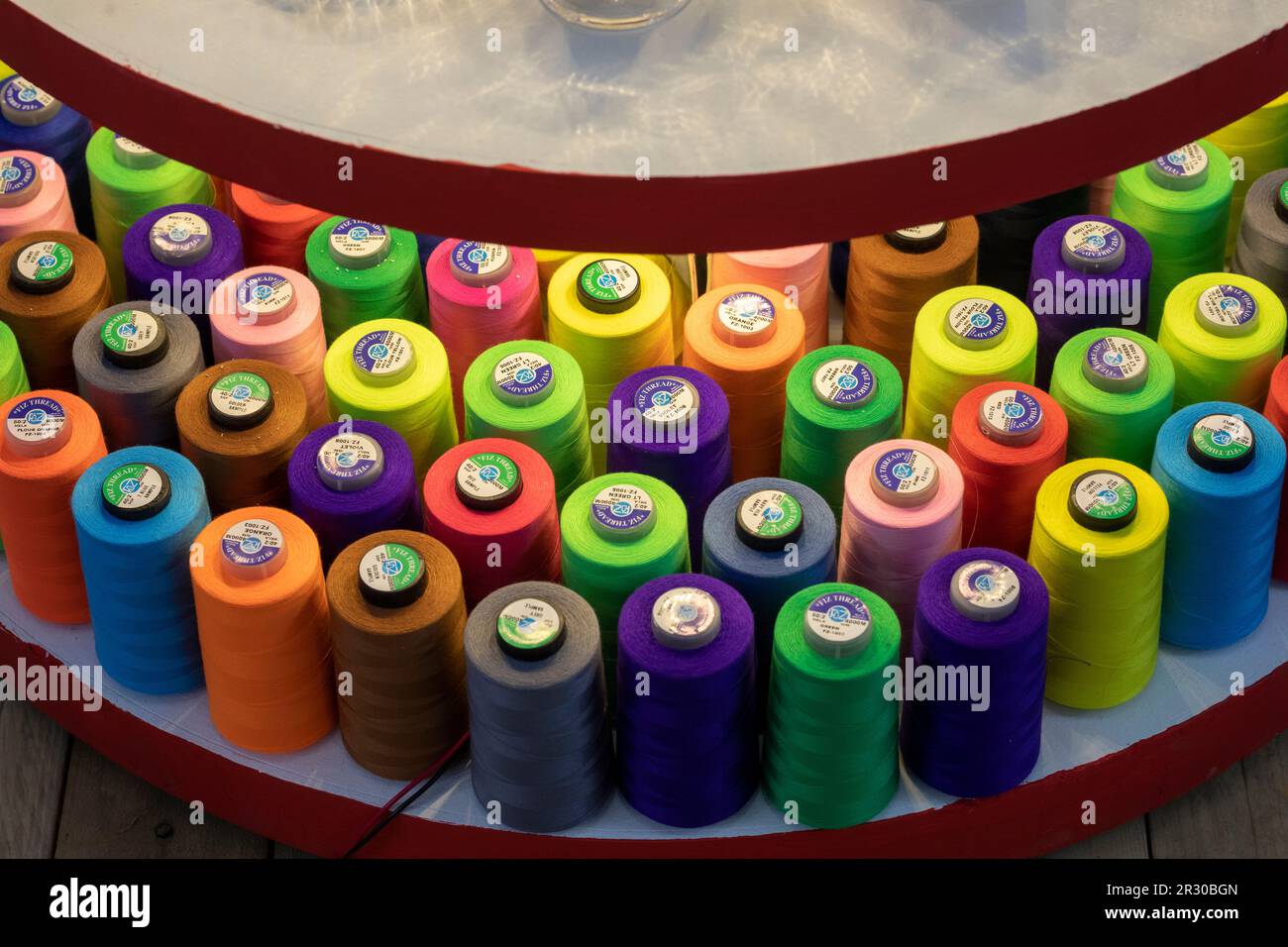 Spools of colorful thread lined in rows are in display at a stall of ...