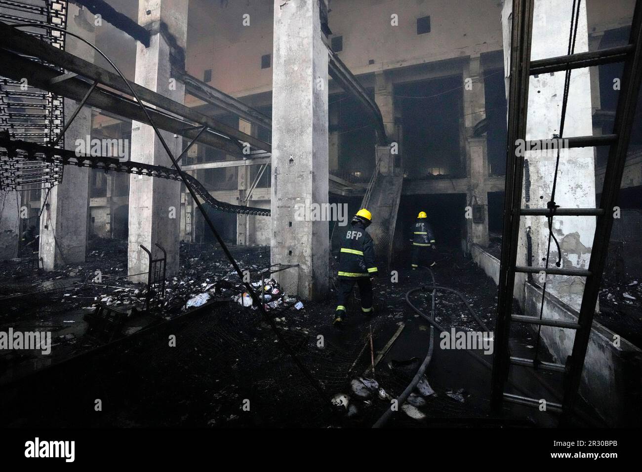 Firemen walk inside the Manila Central Post Office after it caught fire ...