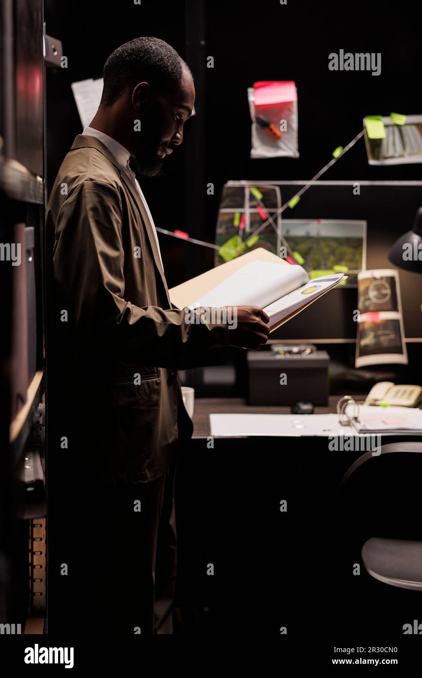 African american detective holding folder with clues analysis report ...