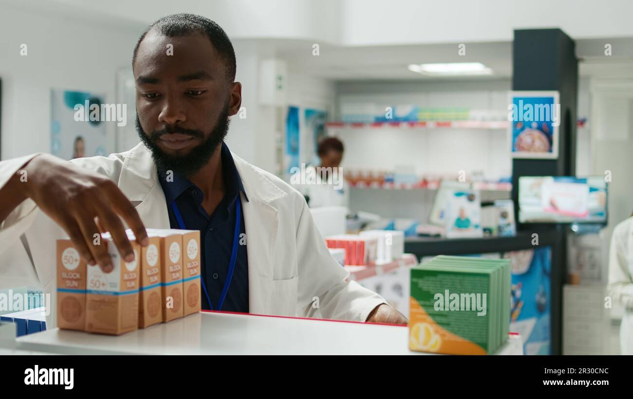 Pharmacy employee arranging stock of medicaments Stock Photo - Alamy
