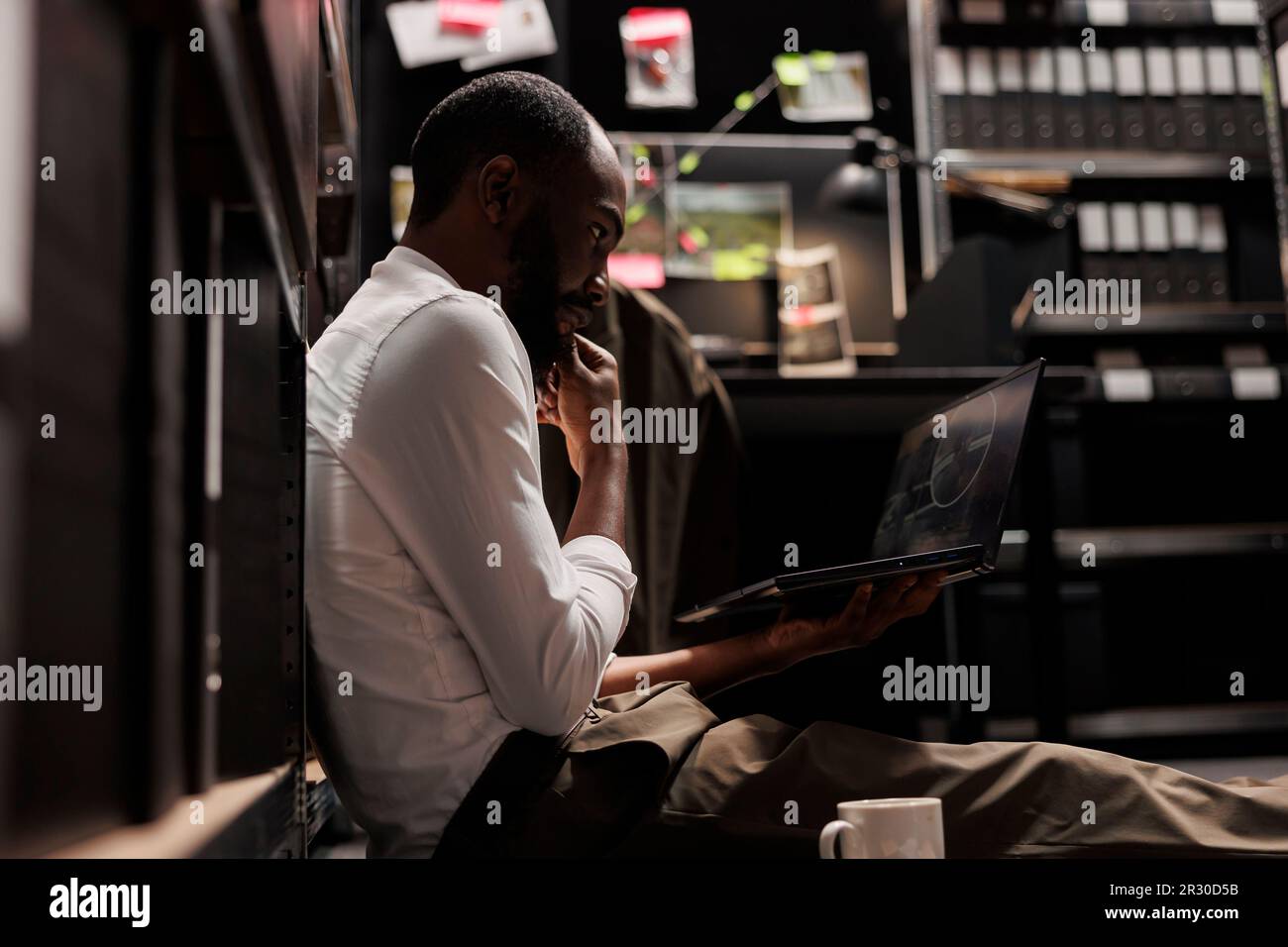 Concentrated investigator looking at cctv camera records on laptop ...