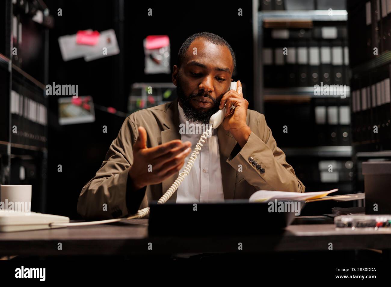Private Detective Explaining Evidence To Client On Landline Phone Stock