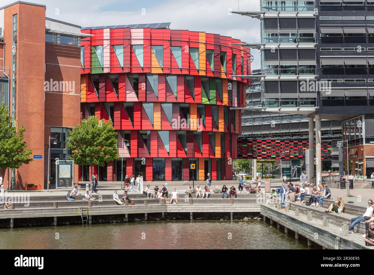 People on pier at Lindoholmspiren by red Kuggan (Cogwheel) building ...