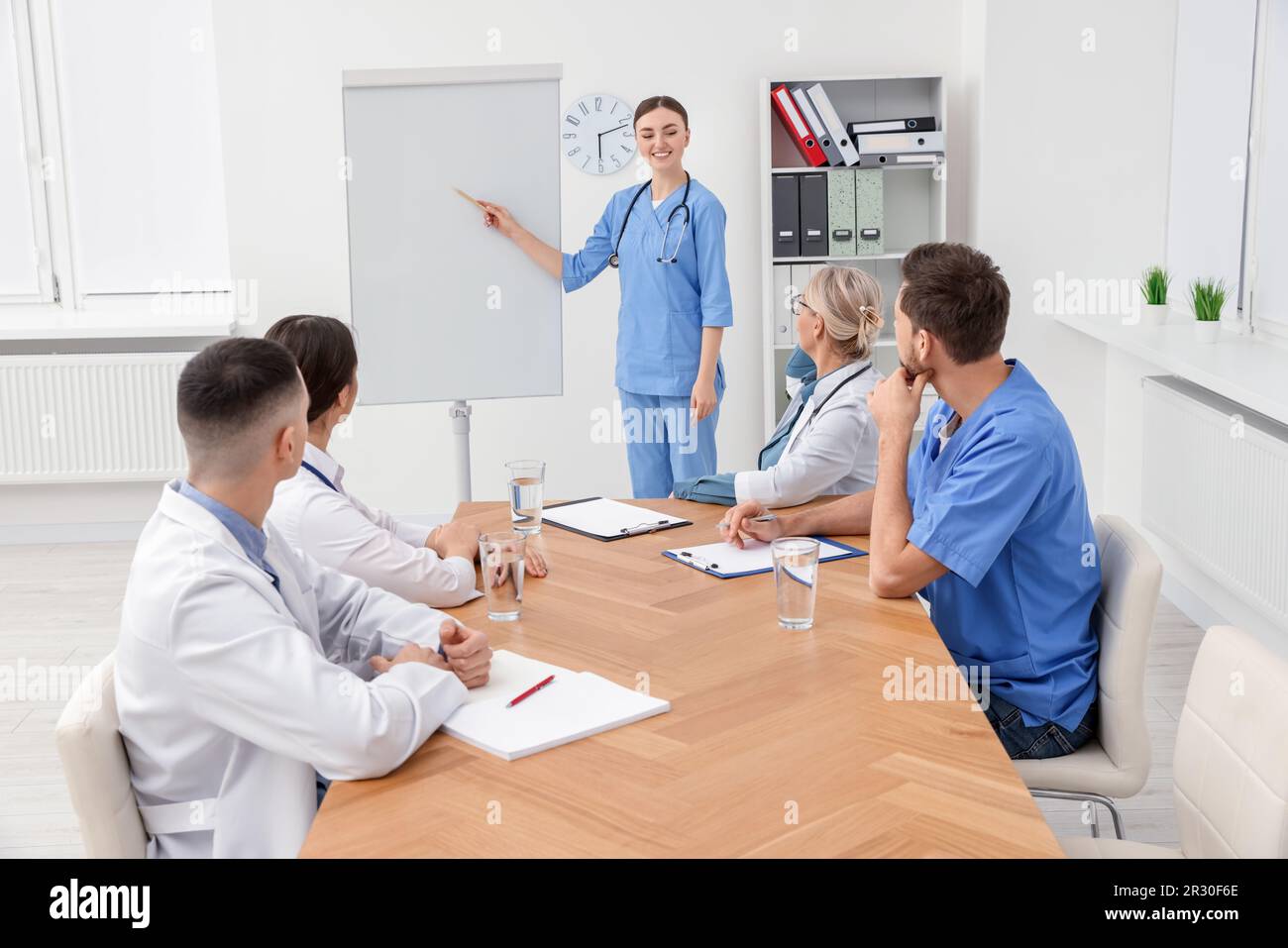 Doctor giving lecture near flipchart in conference room Stock Photo - Alamy