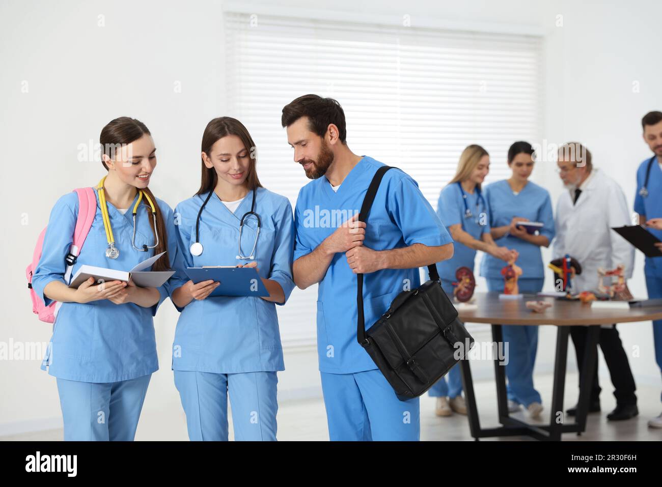 Medical students wearing uniforms in university hallway Stock Photo - Alamy