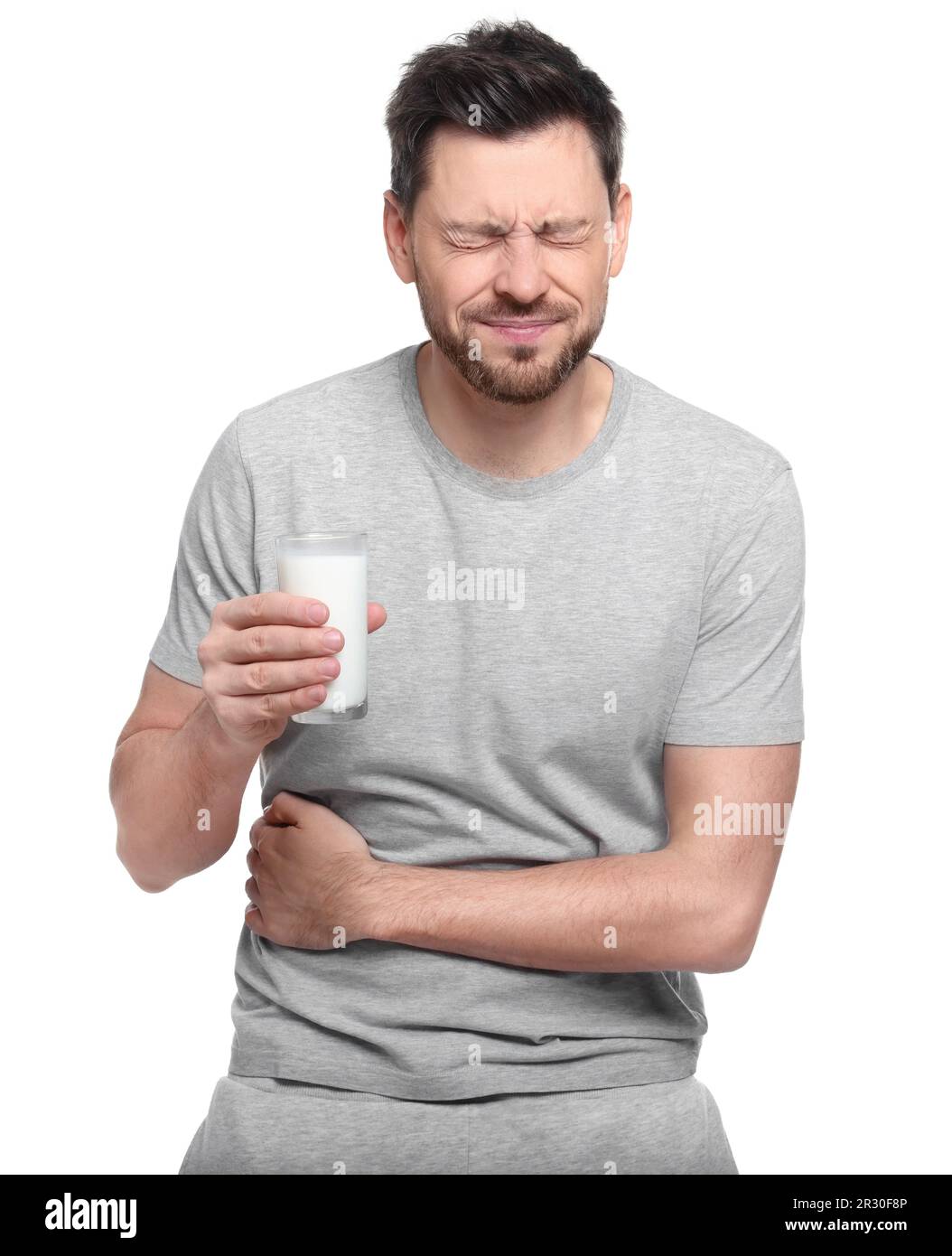 Man with glass of milk suffering from lactose intolerance on white ...