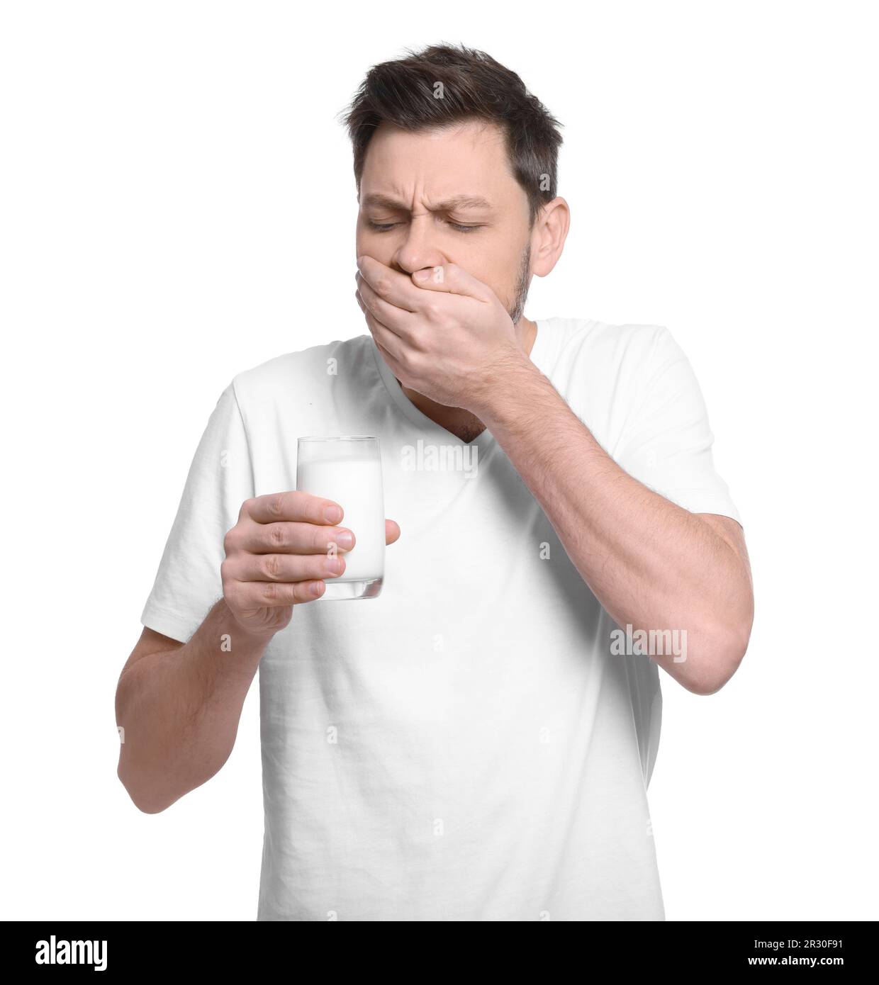 Man with glass of milk suffering from lactose intolerance on white ...