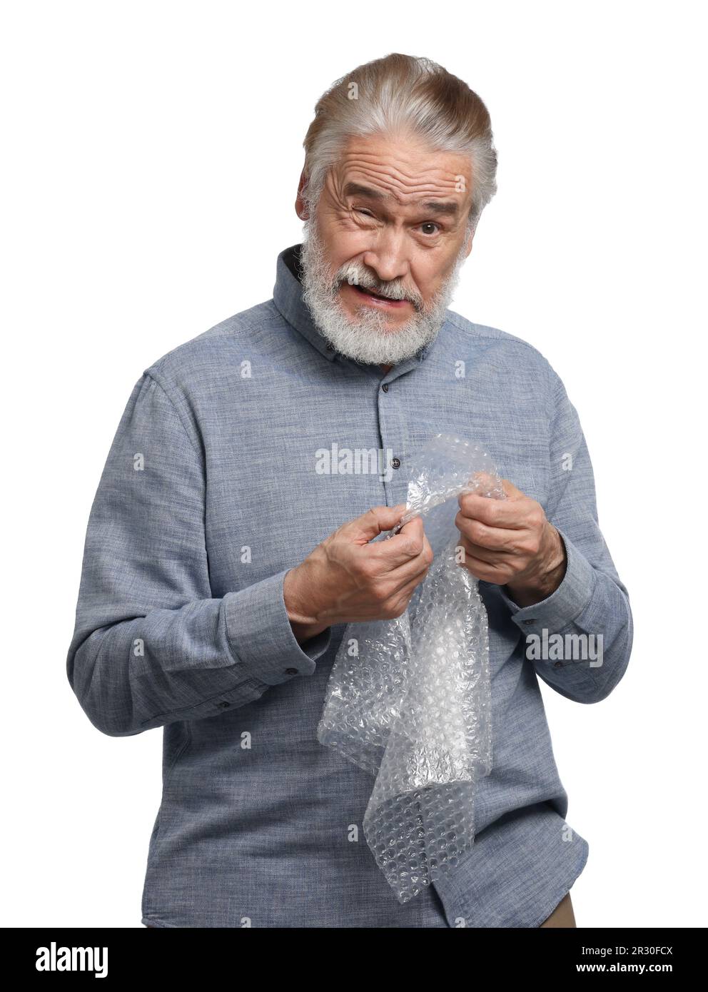 Emotional senior man popping bubble wrap on white background. Stress ...