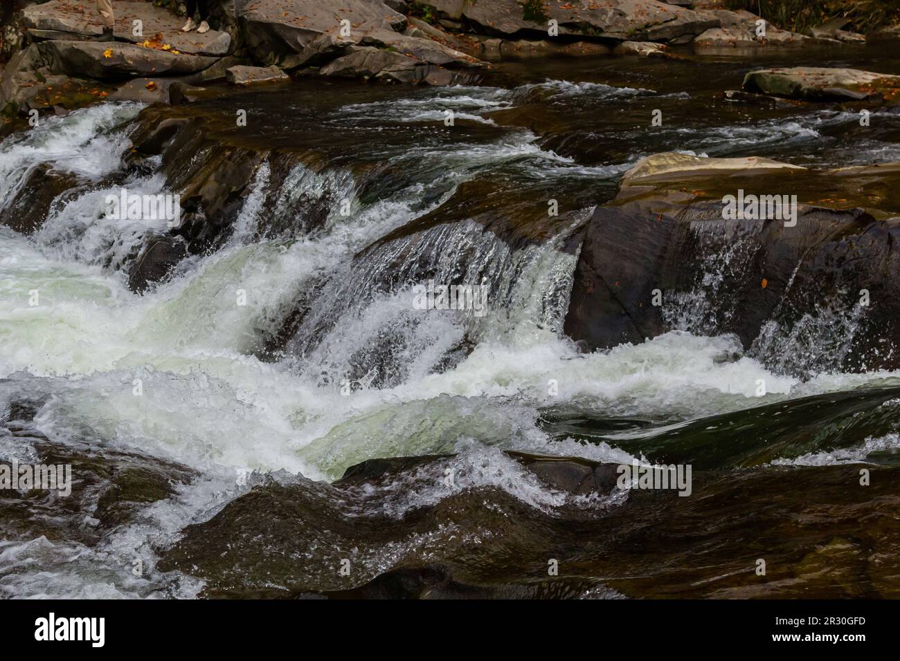 The stream of water flowing over rocks.Image close-up Stock Photo - Alamy