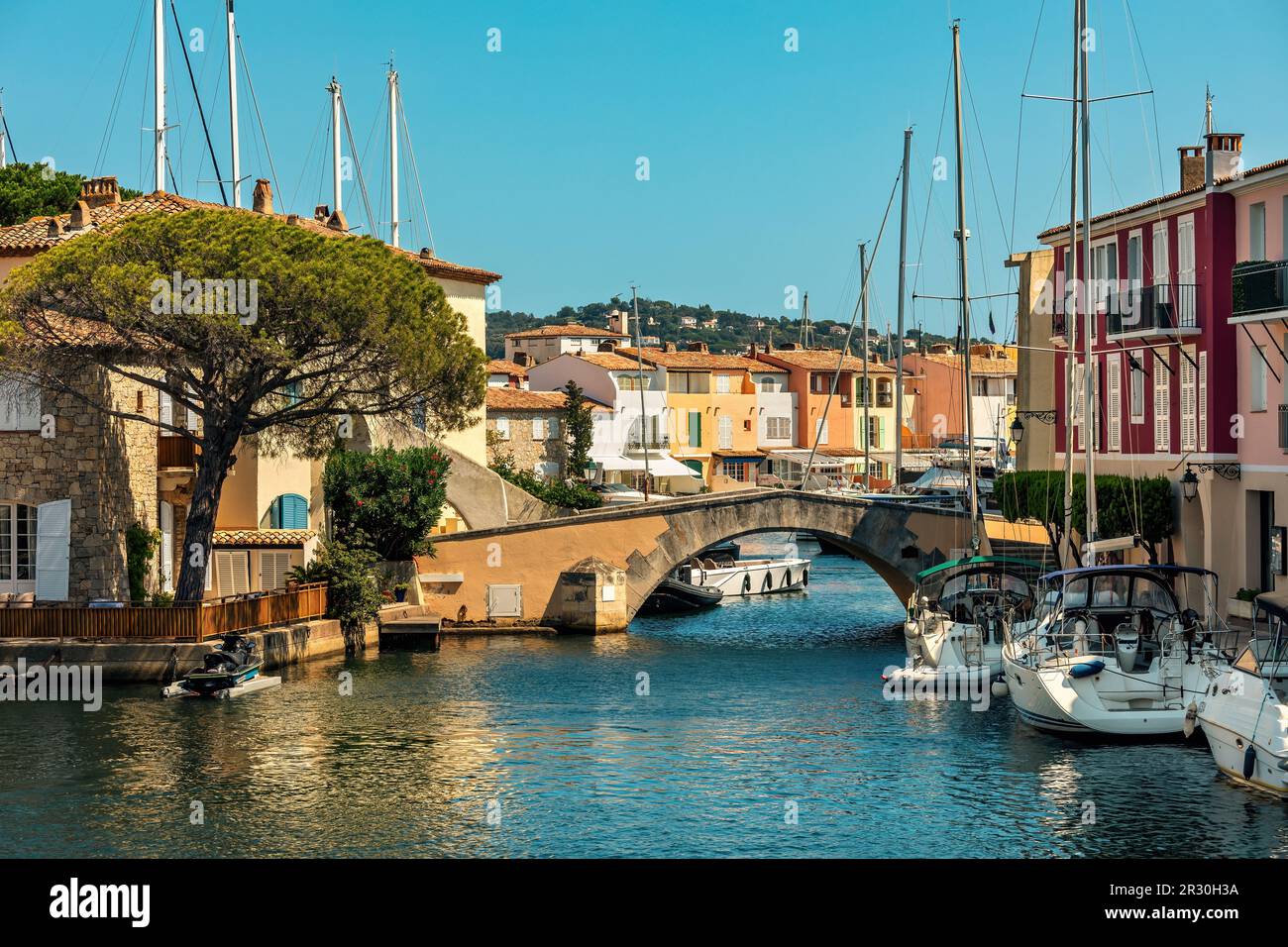 Yachts on the canal among houses and bridge in the town of Port Grimaud ...