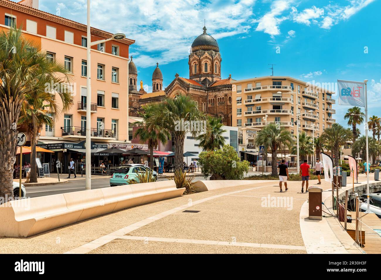 Promenade, buildings and cathedral under blue sky on background in ...