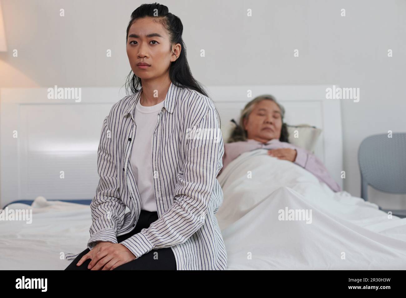 Elderly woman sitting on bed crying hi-res stock photography and images ...