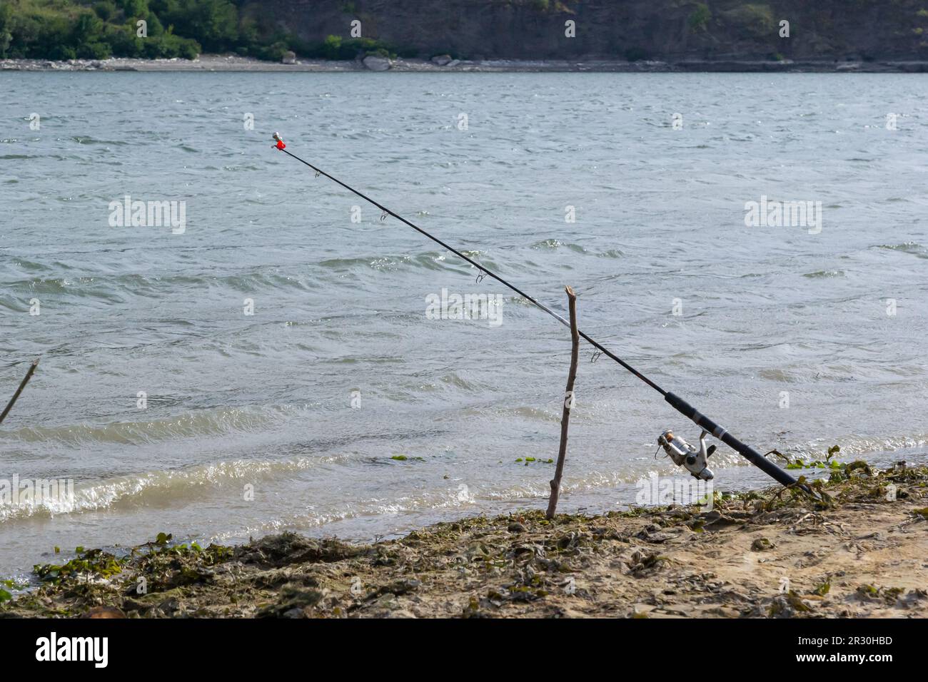 Fishing rods and fishing gear on the river bank, lake coast close up ...
