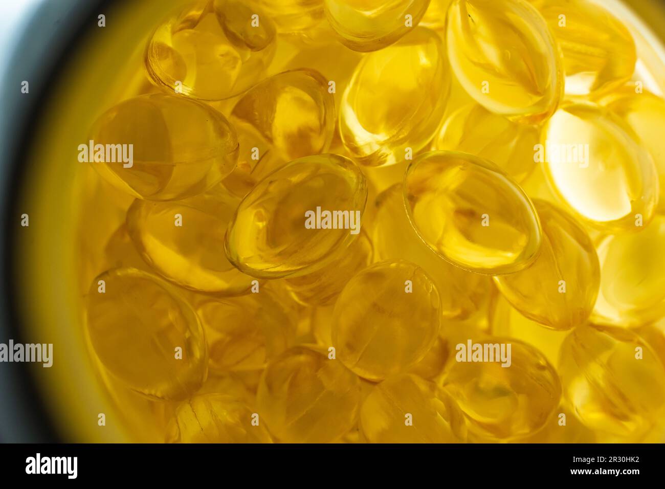 lots of yellow gelatin capsules on a light background. omega viramins ...