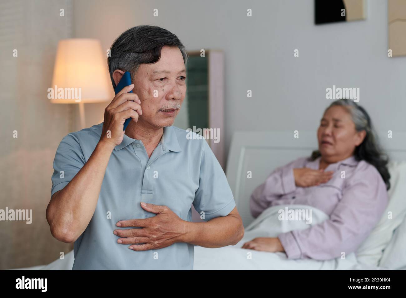 Worried elderly man calling ambulance when his wife having heart attack Stock Photo - Alamy
