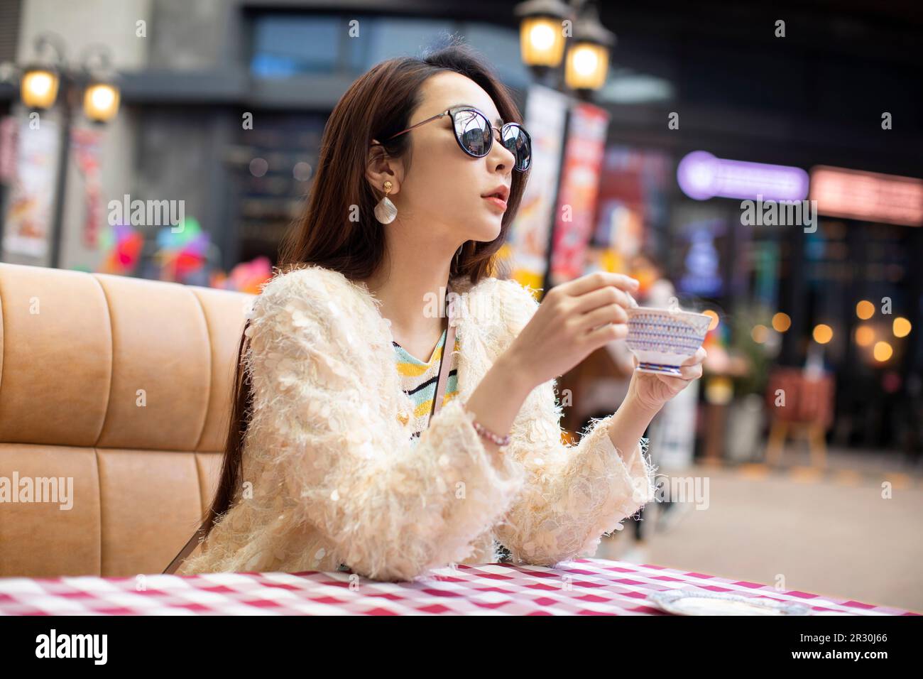Cheerful young Chinese woman drinking coffee in café Stock Photo - Alamy