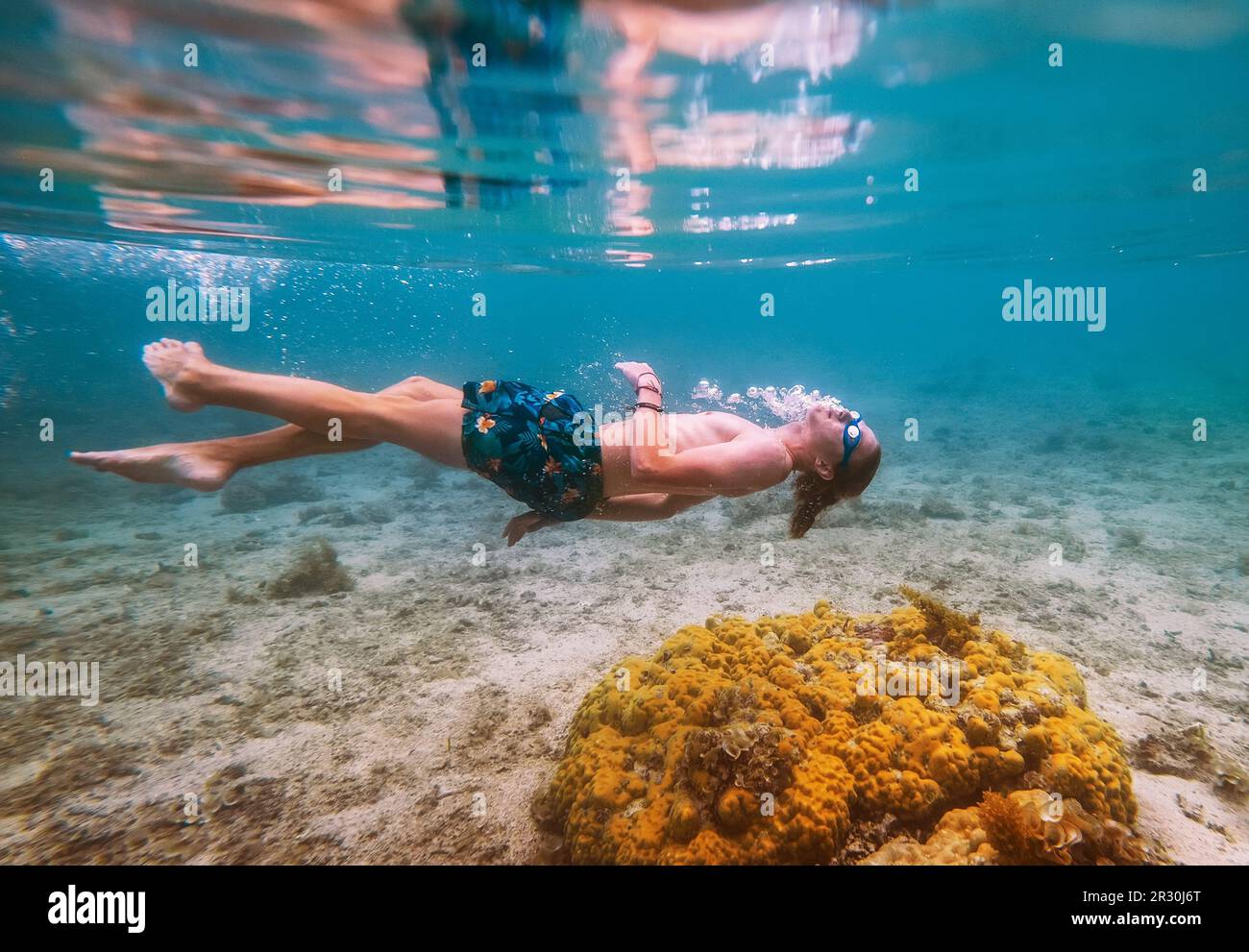 Diving teenage boy snorkeling in underwater glasses making bubbles over ...