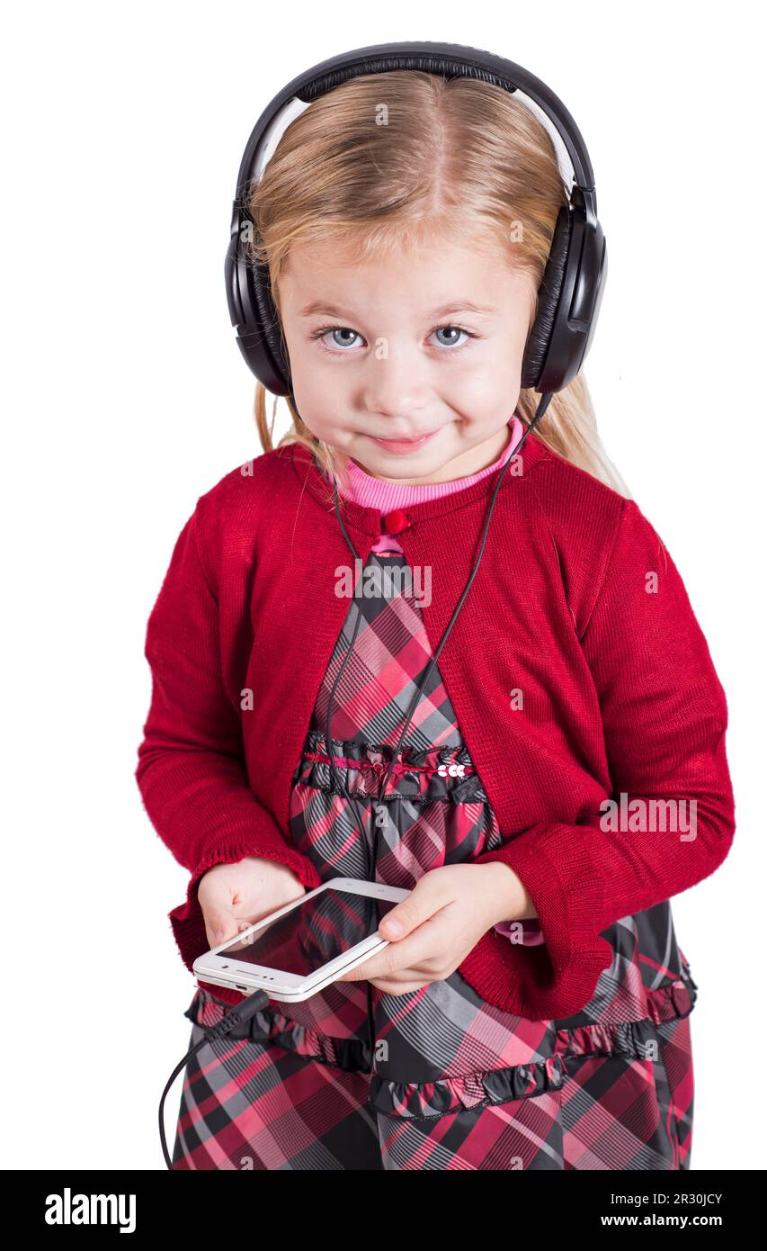 Little blonde girl smiling listening to music on smart phone mobile ...