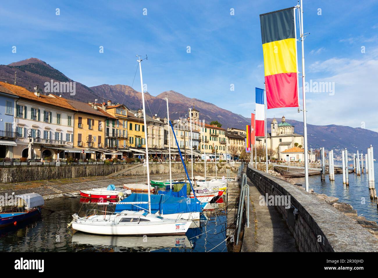 Cannobio waterfront along Lago Maggiore with boats in harbour on winter ...