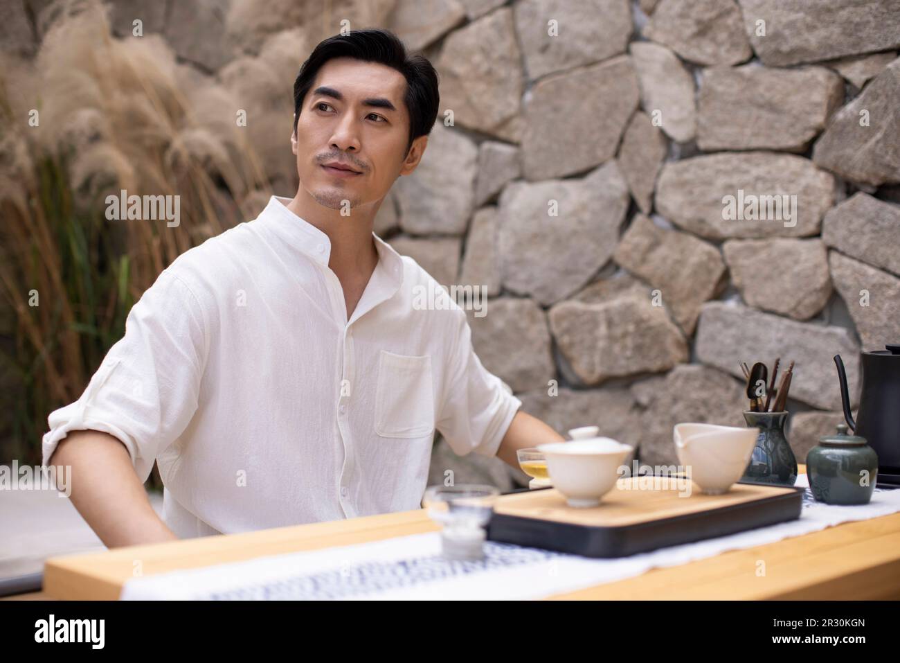 Mid adult Chinese man drinking tea in tea room Stock Photo - Alamy