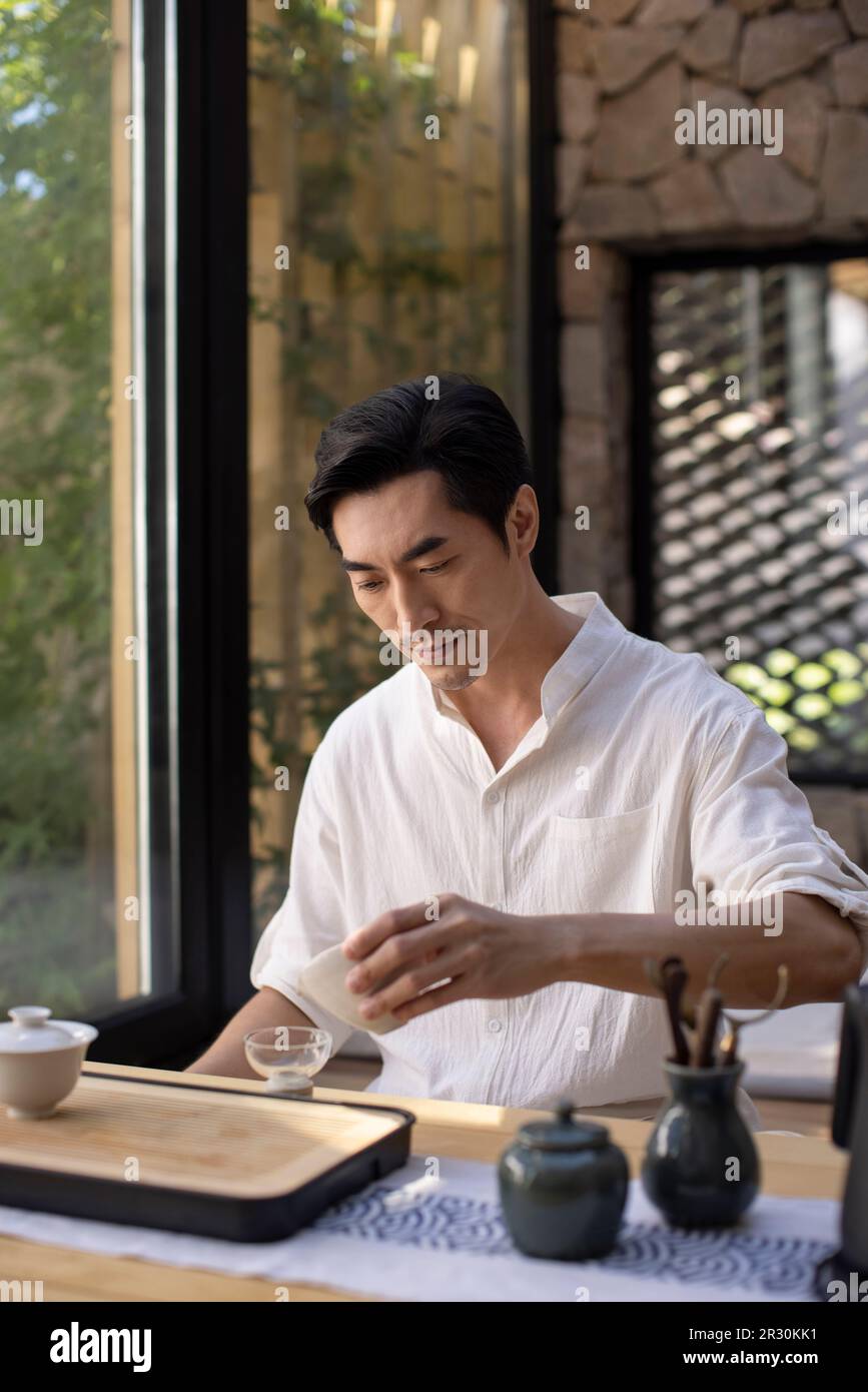Mid adult Chinese man drinking tea in tea room Stock Photo - Alamy