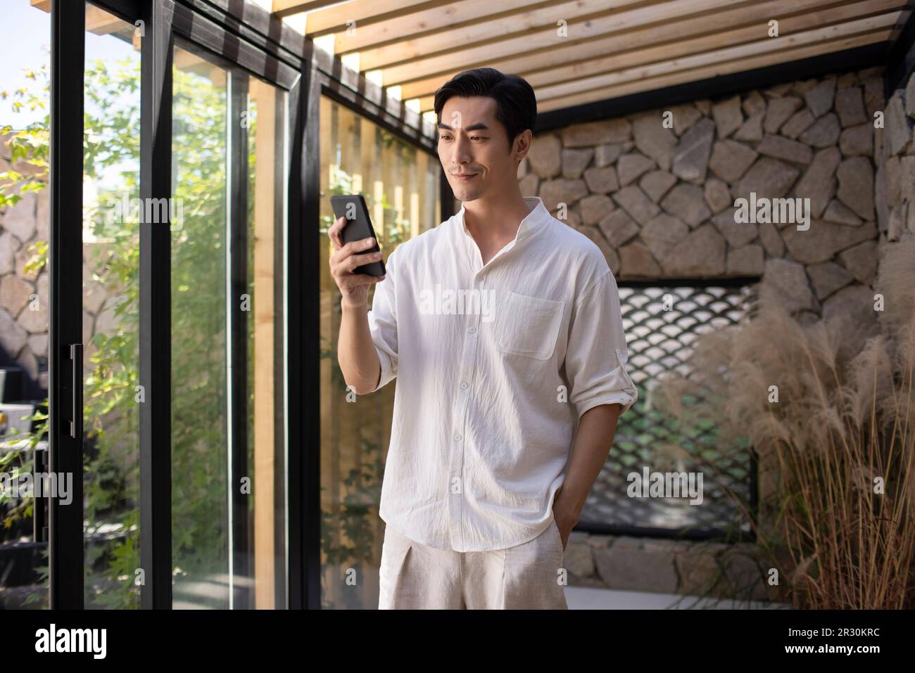 Happy mid adult Chinese man using smart phone Stock Photo - Alamy