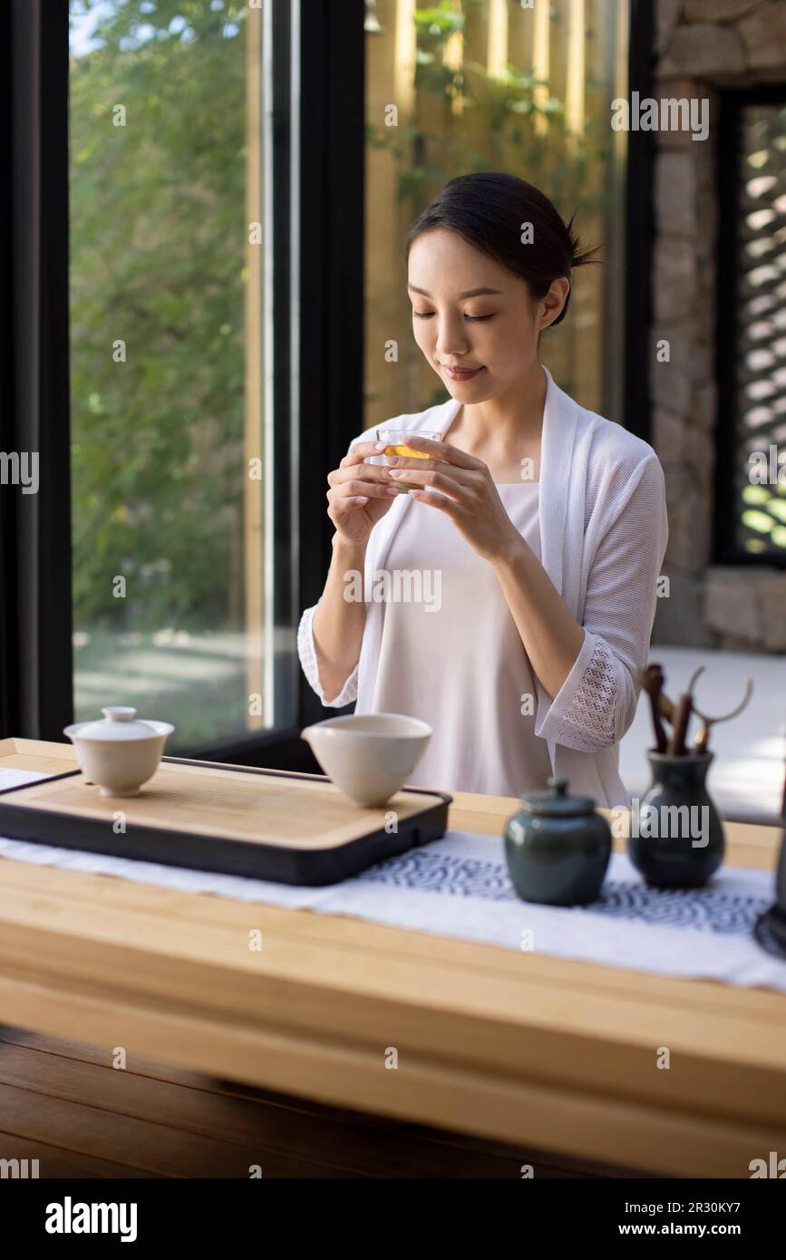 Elegant young Chinese woman drinking tea in tea room Stock Photo - Alamy