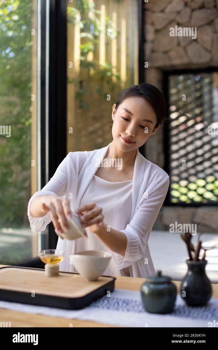 Elegant young Chinese woman drinking tea in tea room Stock Photo - Alamy