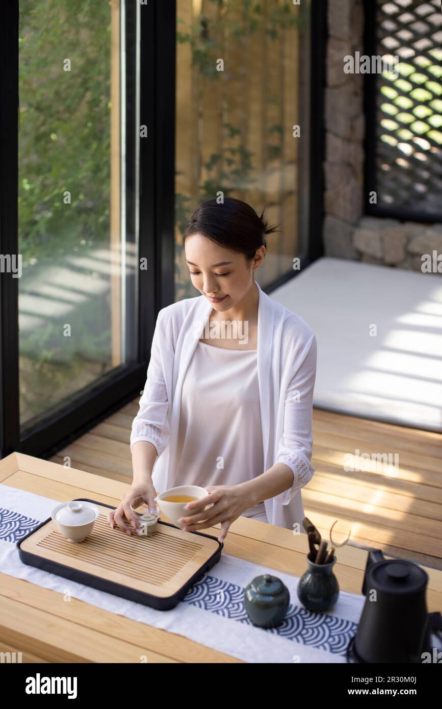 Elegant young Chinese woman drinking tea in tea room Stock Photo - Alamy