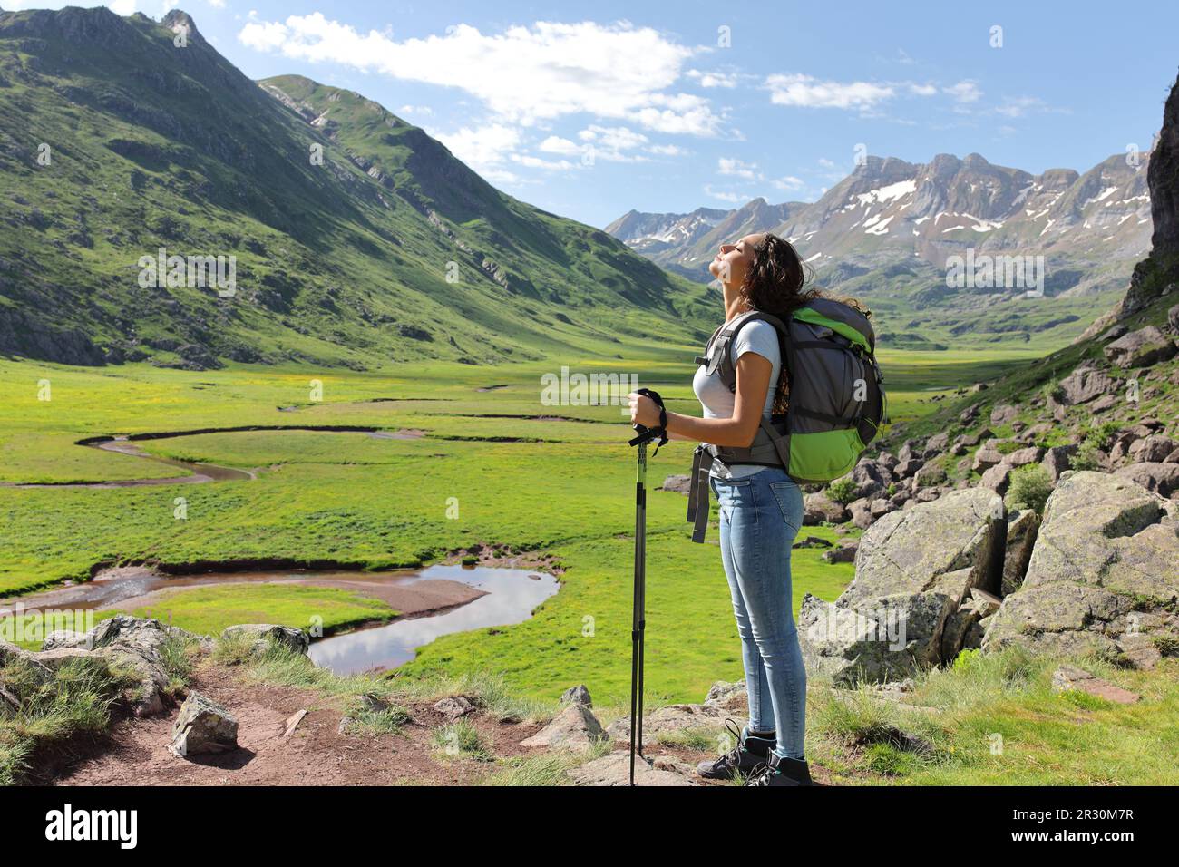 Side view full body portrait of a relaxed hiker breathing fresh air in ...