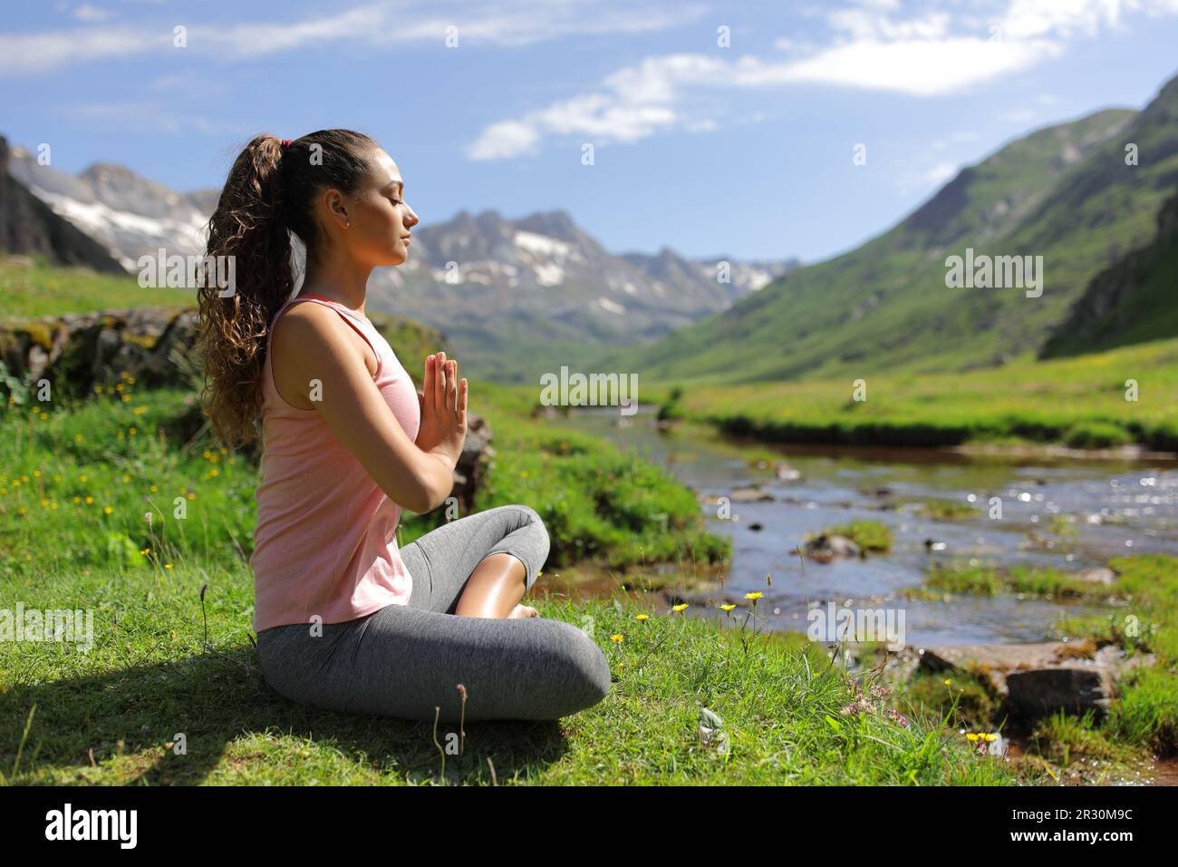 Side view portrait of a yogi beginning yoga exercise in the mountain ...