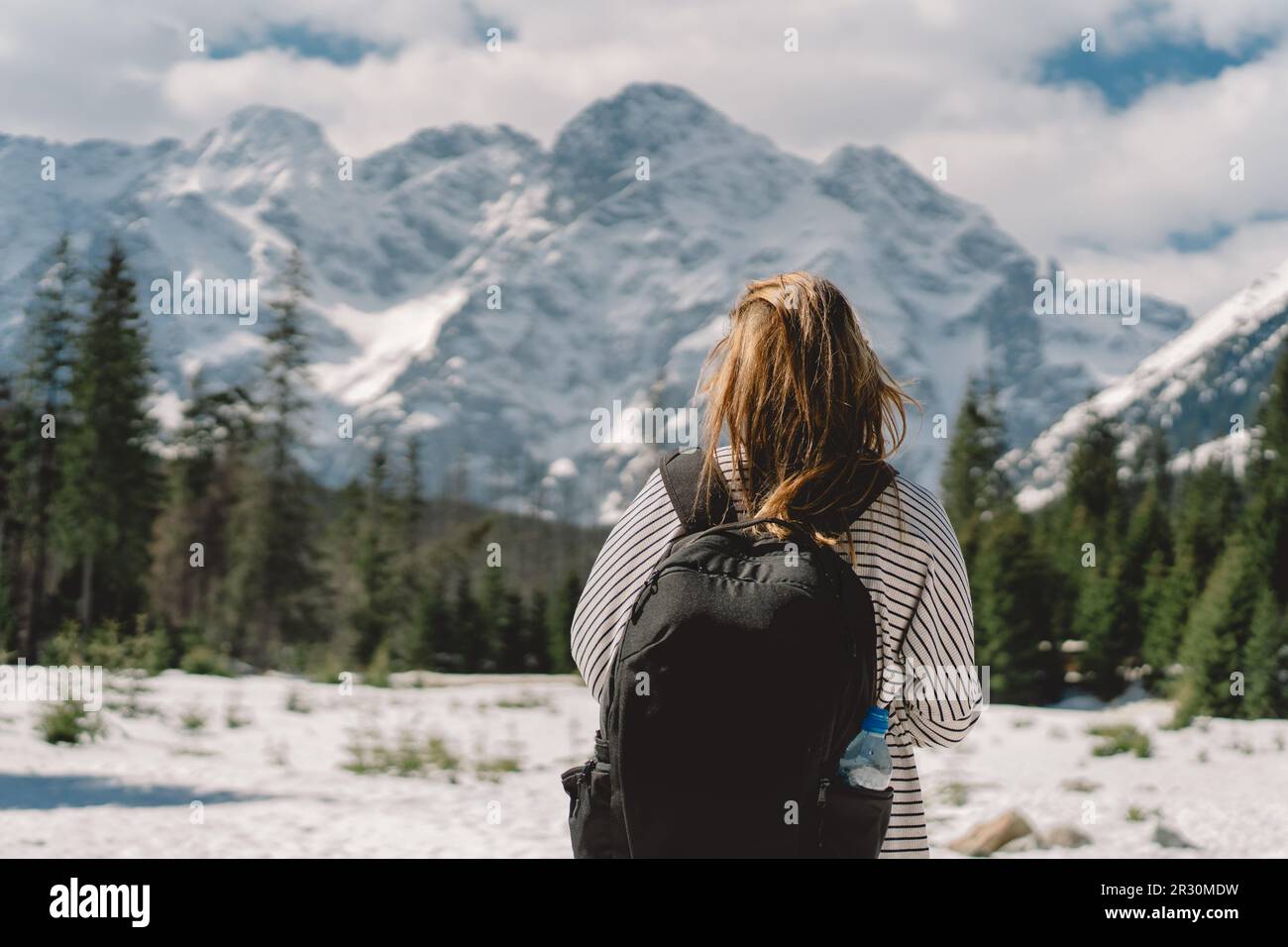 Back view of a girl traveler wearing a backpack traveling alone Stock ...
