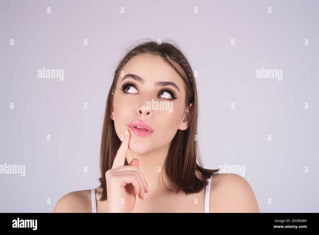 Thinking concept. Portrait of focused smart and creative woman, holding ...