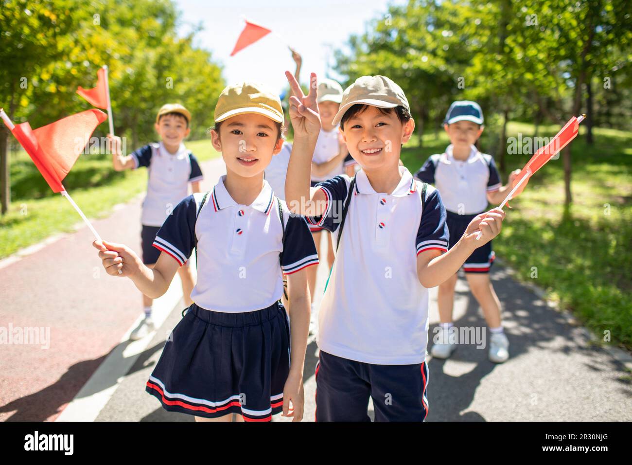 Cheerful Chinese school children relaxing in park Stock Photo - Alamy