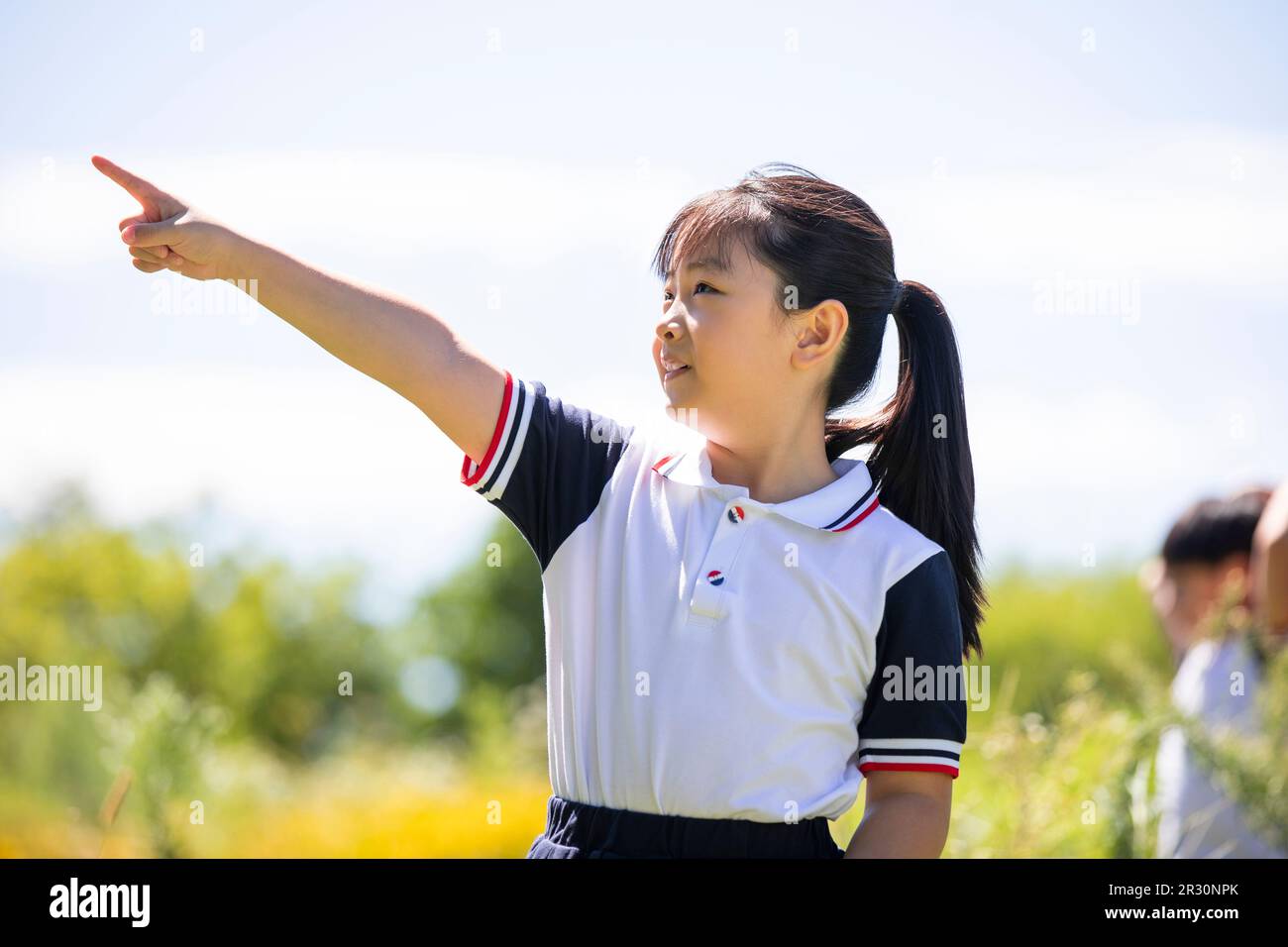 Smiling chinese girl pointing hi-res stock photography and images - Alamy