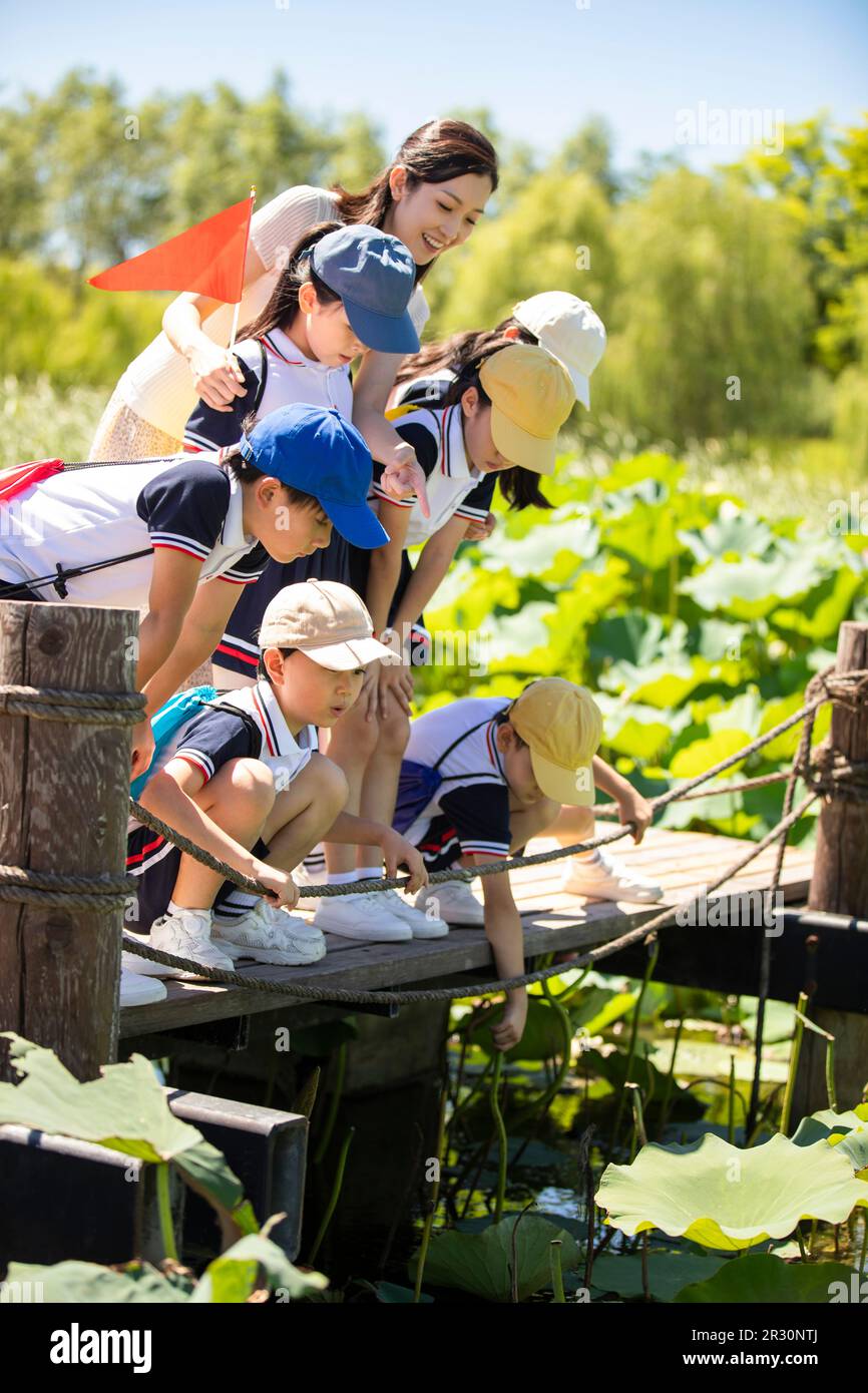 Cheerful Chinese school children relaxing in park with their teacher Stock Photo - Alamy