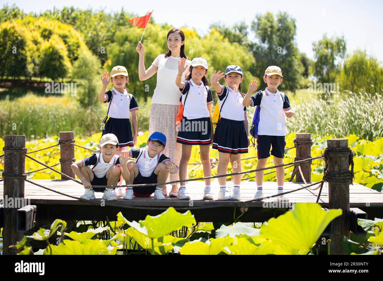 Cheerful Chinese school children relaxing in park with their teacher Stock Photo - Alamy
