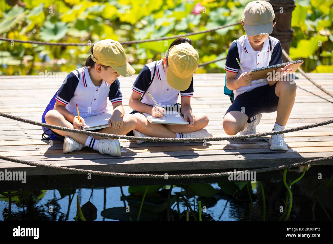 Cheerful Chinese school children drawing in park Stock Photo - Alamy