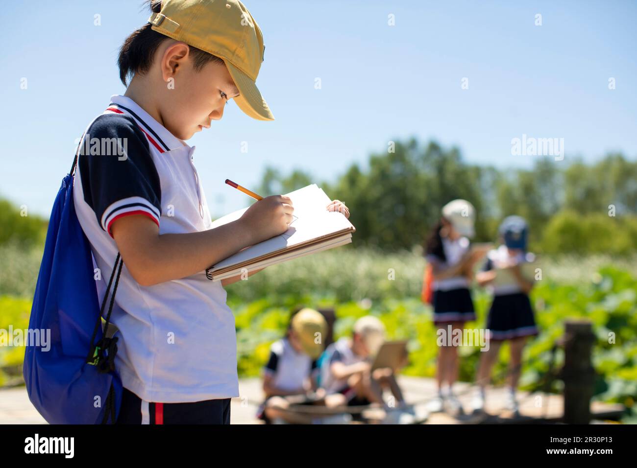Cheerful Chinese school children drawing in park Stock Photo - Alamy