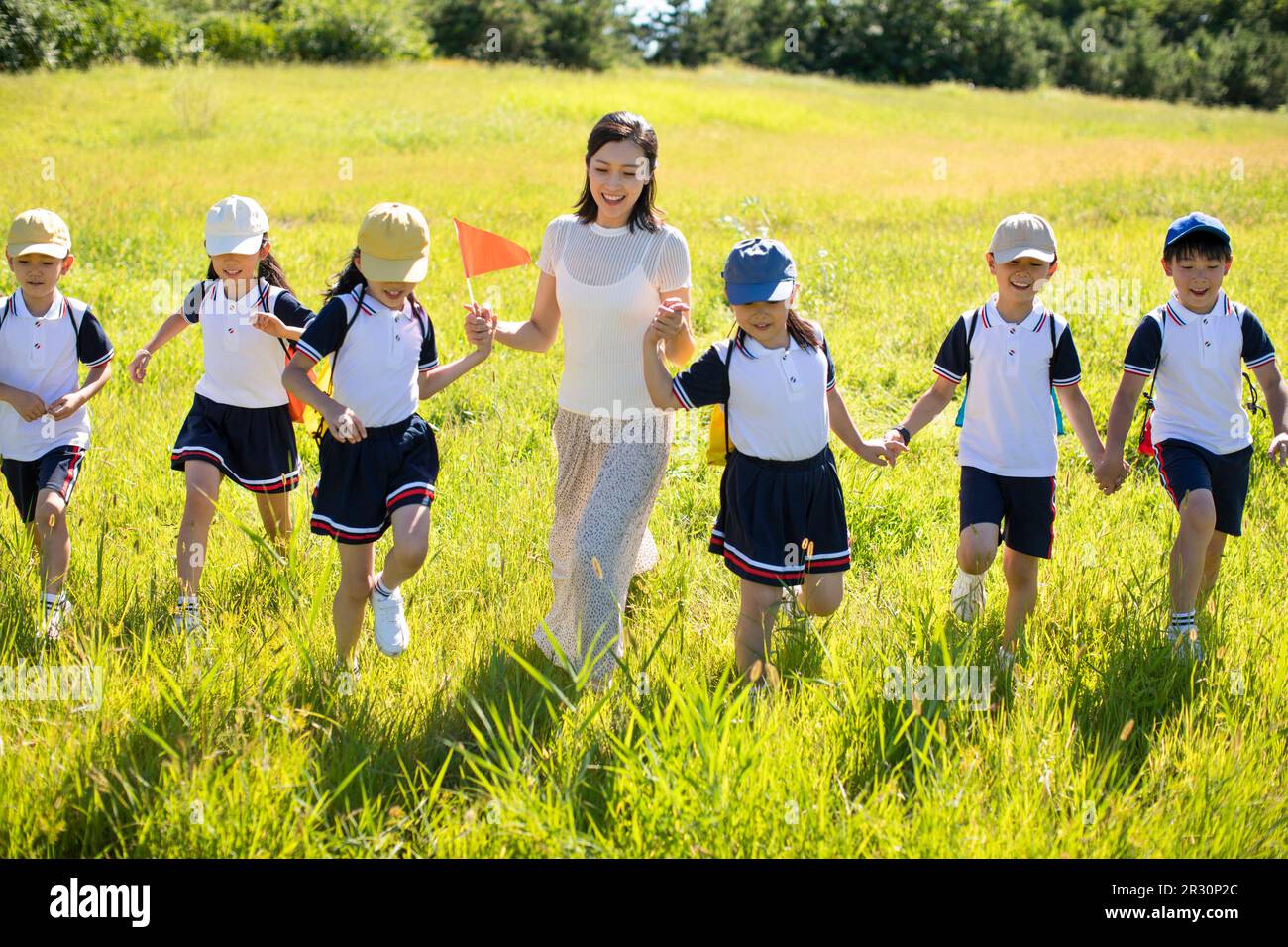 Cheerful Chinese school children relaxing in park with their teacher Stock Photo - Alamy