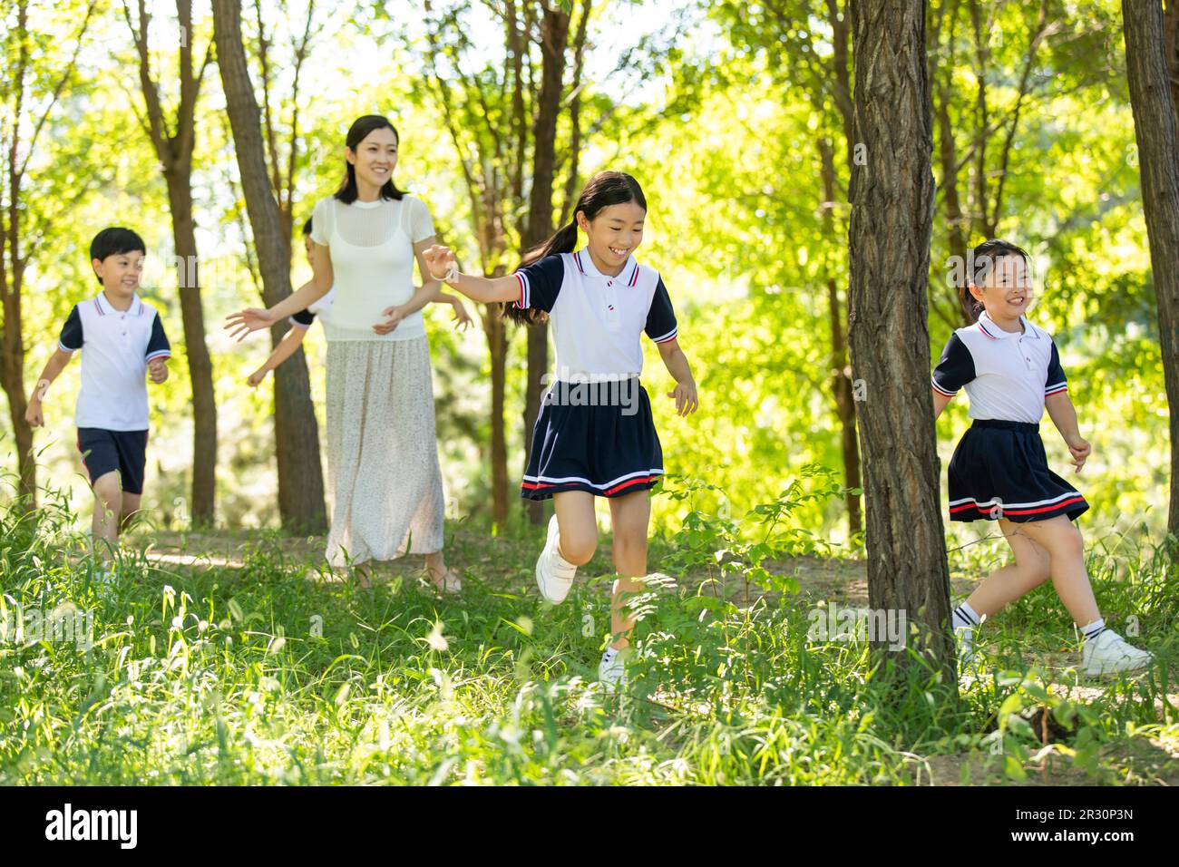 Cheerful Chinese school children relaxing in park with their teacher Stock Photo - Alamy