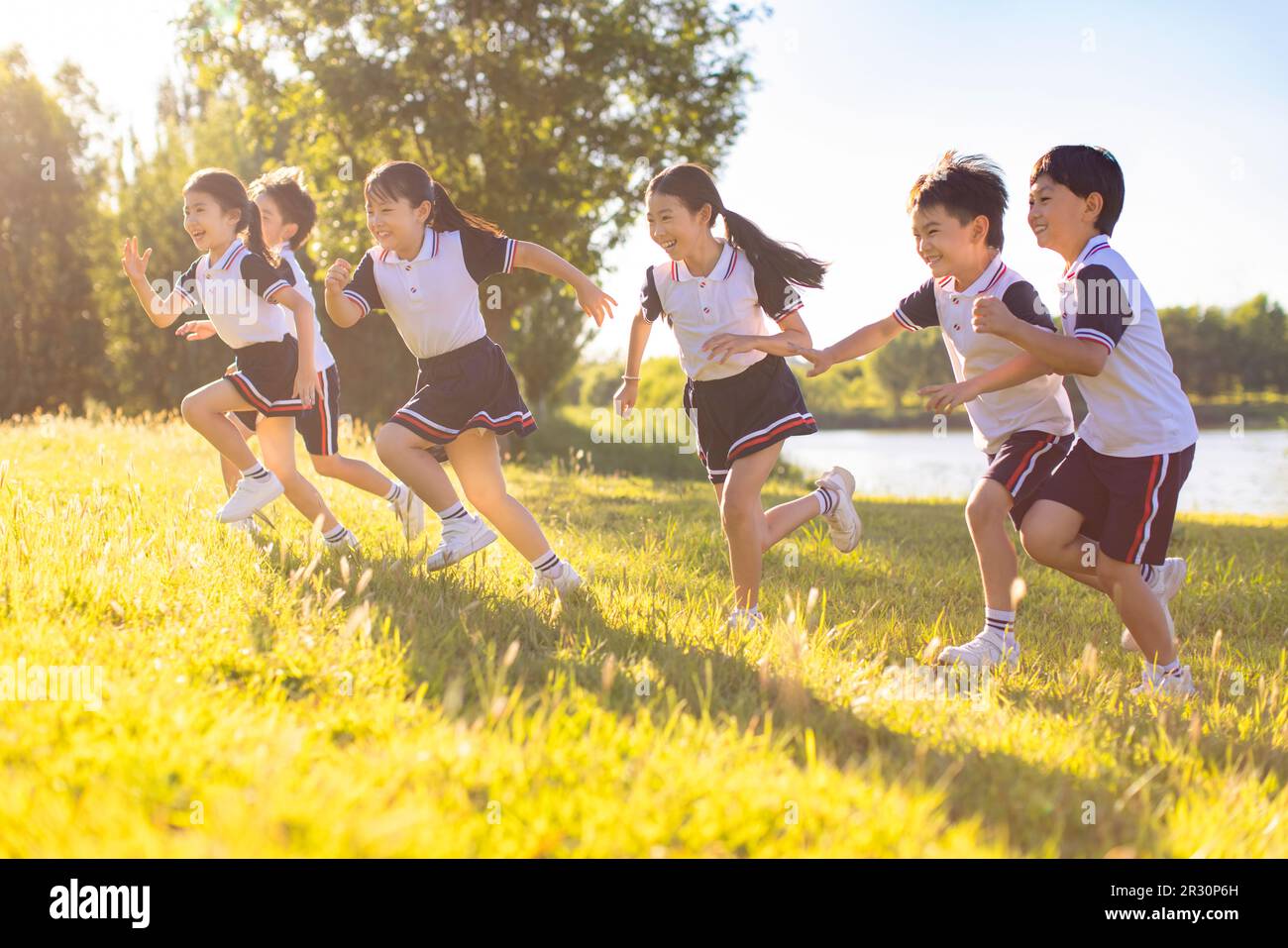 Cheerful Chinese school children relaxing in park Stock Photo - Alamy
